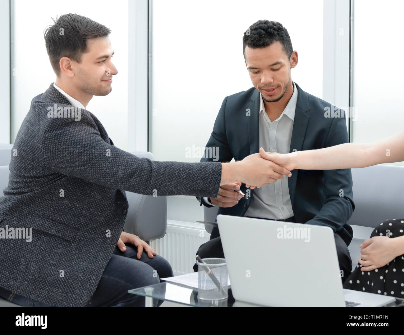 young business partners shaking hands at a business meeting Stock Photo - Alamy
