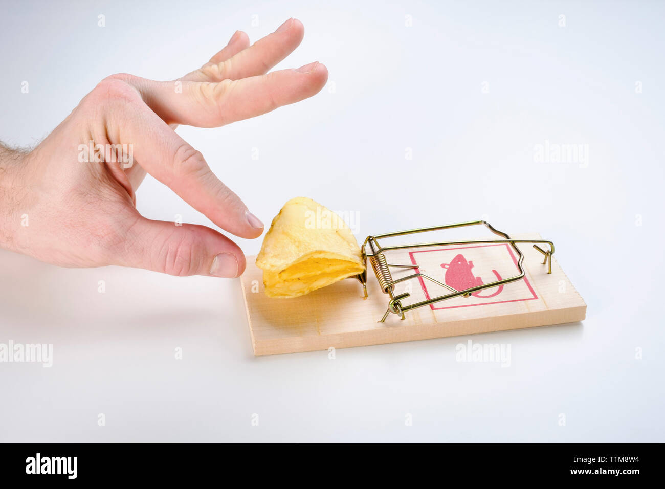 Hand reaching for potato chips on mousetrap Stock Photo - Alamy