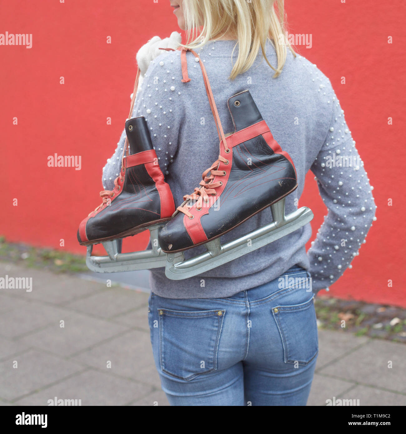 Woman carrying ice skates over shoulder Stock Photo - Alamy
