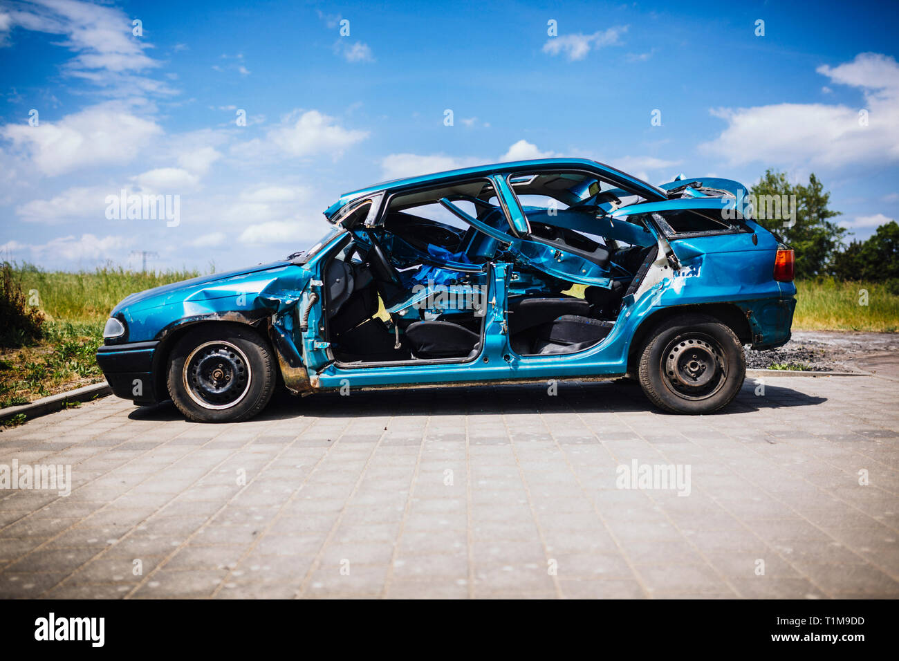 Mangled blue car in sunny parking lot Stock Photo - Alamy