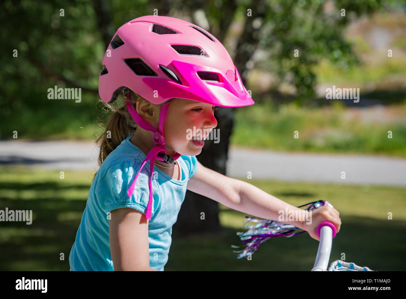 Cute little girl riding bike. Happy active kid. Sunny summer day on ...