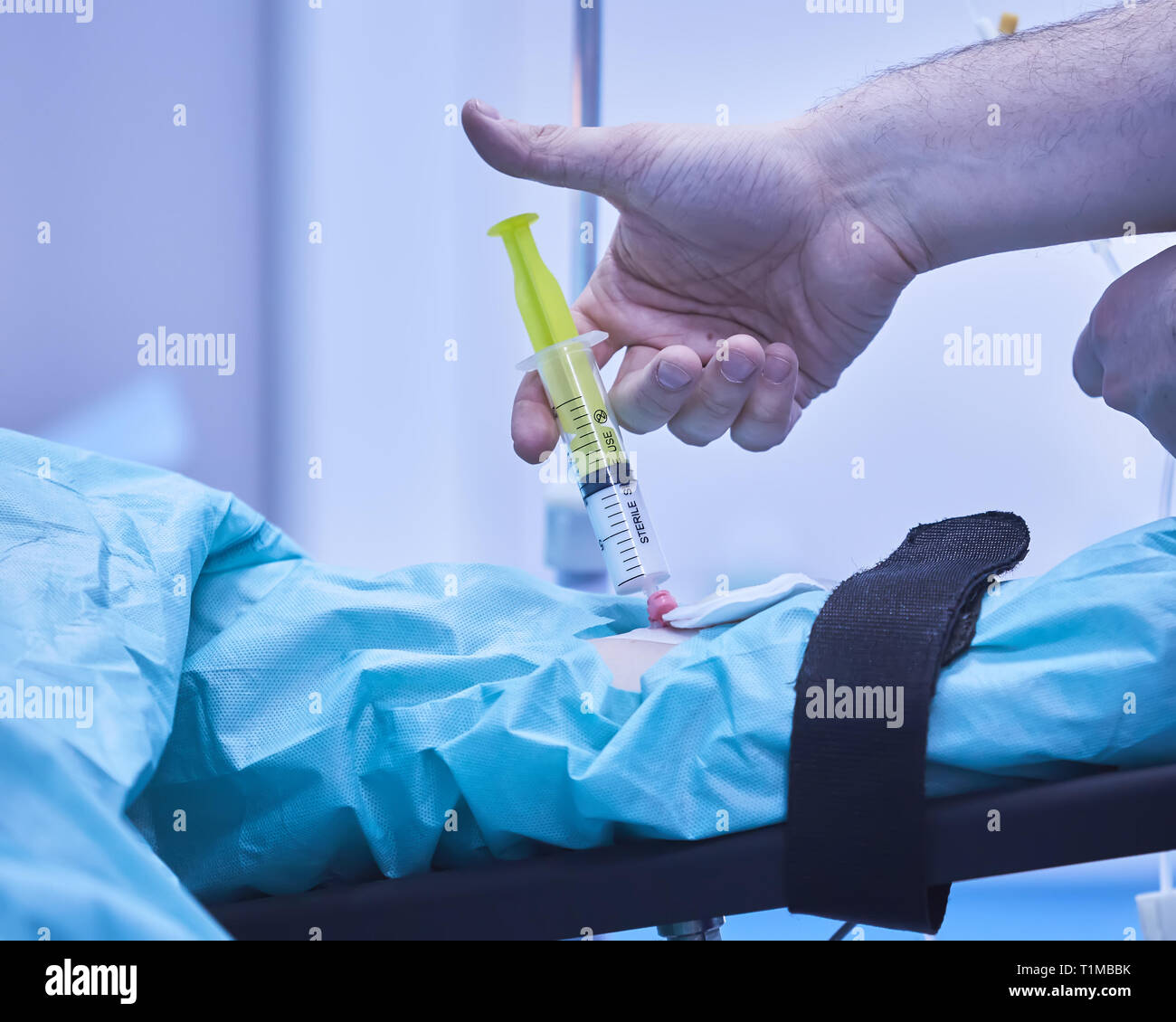 Selective focus on doctor hand in blue latex glove with syringe giving ...