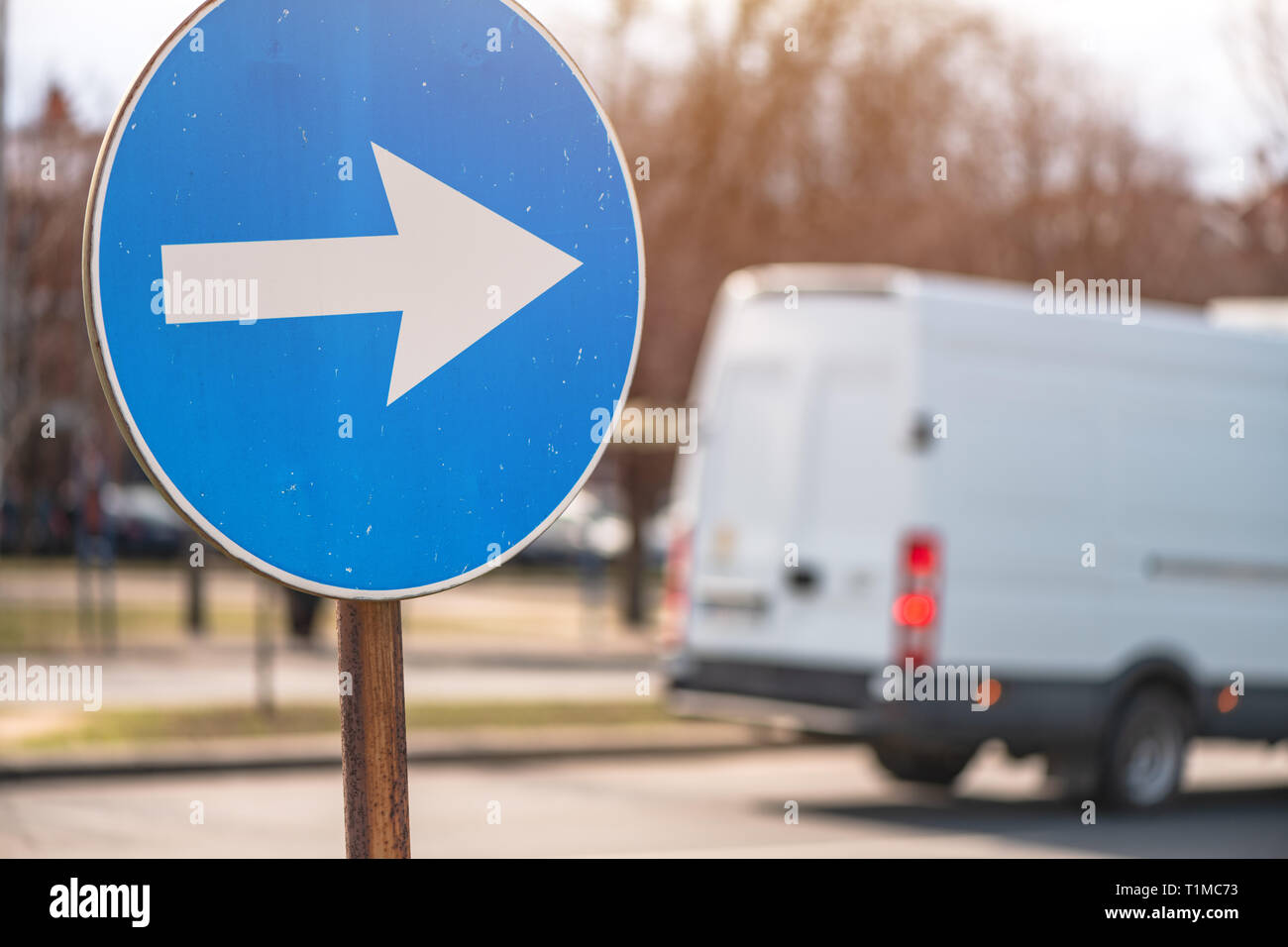 Proceed in direction arrow traffic sign on the street with defocussed ...