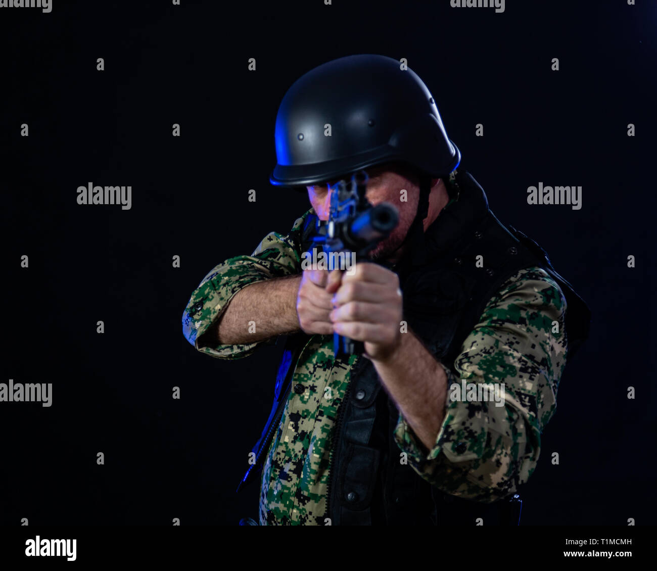 Soldier in army fatigues pointing assault rifle Stock Photo - Alamy