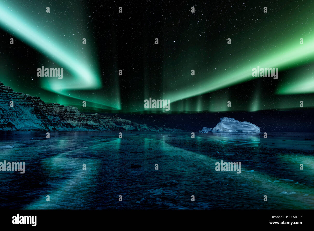 iceberg floating in greenland fjord at night with green northern lights ...