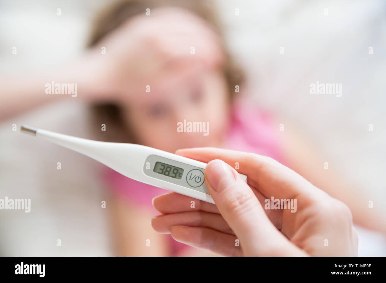 Close-up thermometer. Mother measuring temperature of her ill kid. Sick child with high fever ...