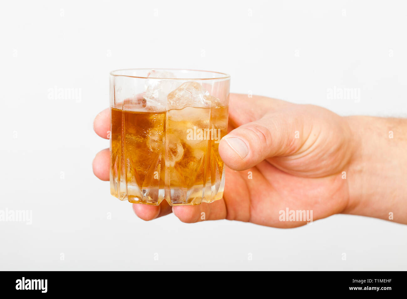 Man's hand holding a glass of whiskey on a white background Stock Photo ...