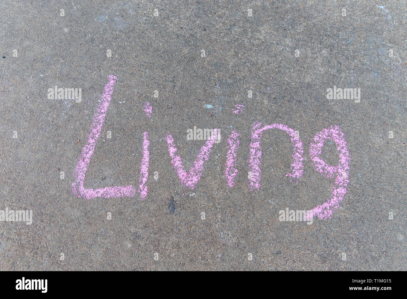 the word Living written with pink sidewalk chalk on gray concrete ...
