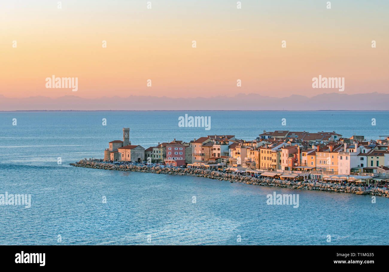 View of old coastal town Piran and adriatic sea, lit by warm evening ...