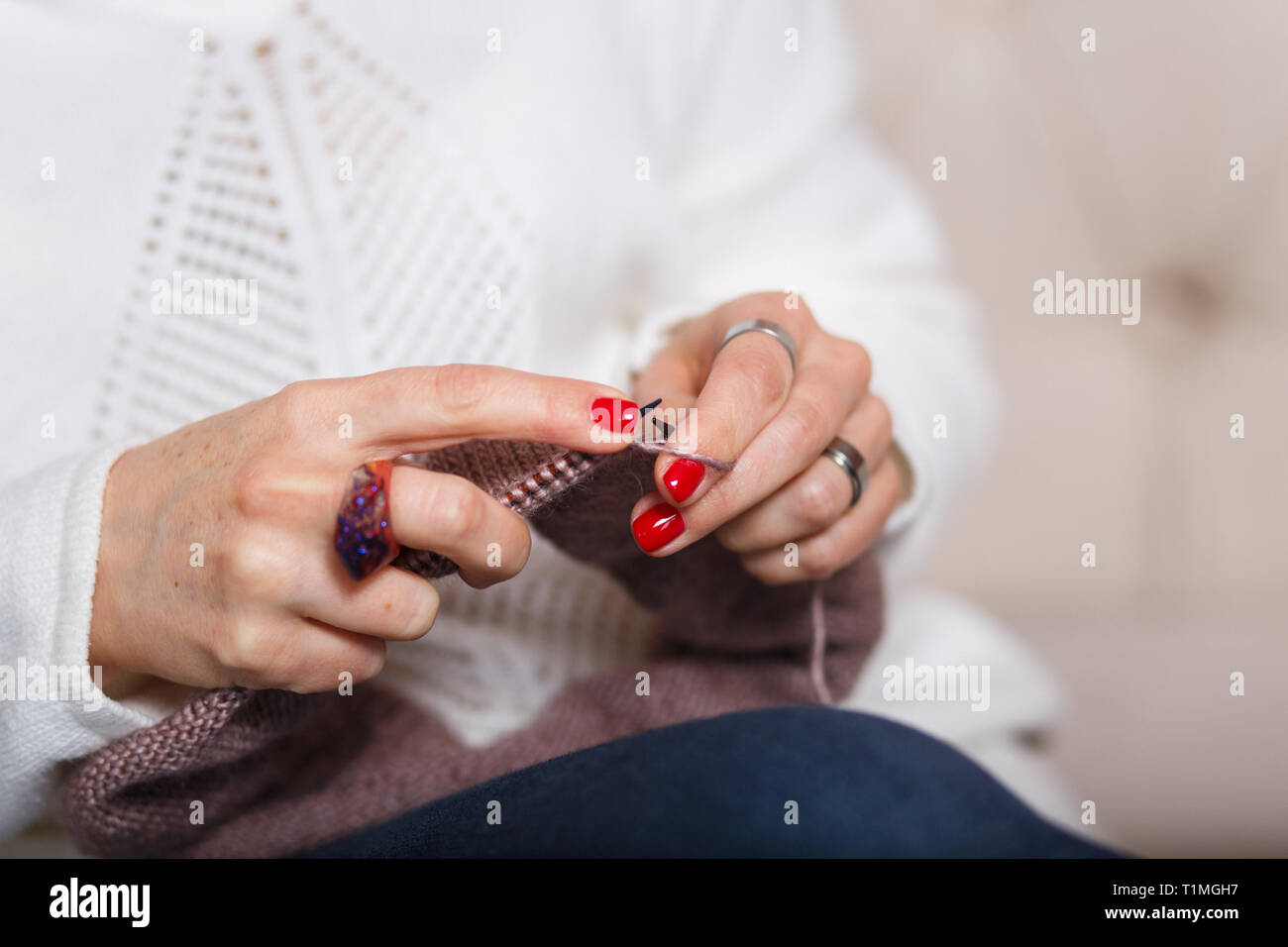 Women's hands knit. The girl knits at the window. Hands close-up ...