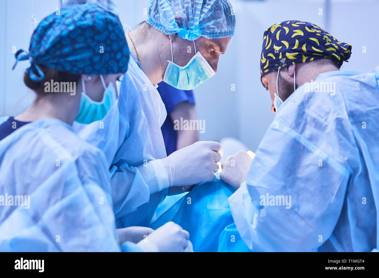 Serious surgeons during a surgery in the hospital. Cross Process Stock ...