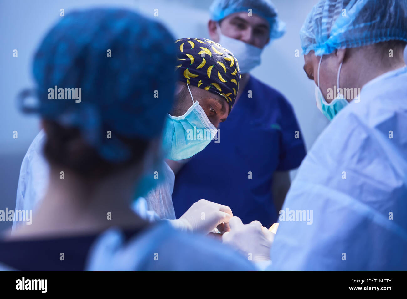 Serious surgeons during a surgery in the hospital. Cross Process Stock ...