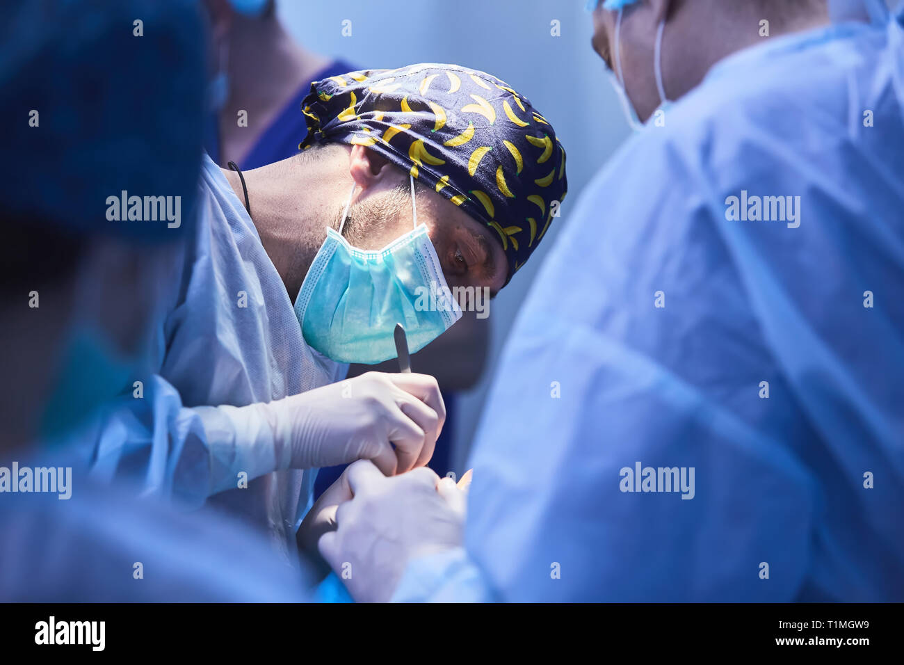 Serious surgeons during a surgery in the hospital. Cross Process Stock ...