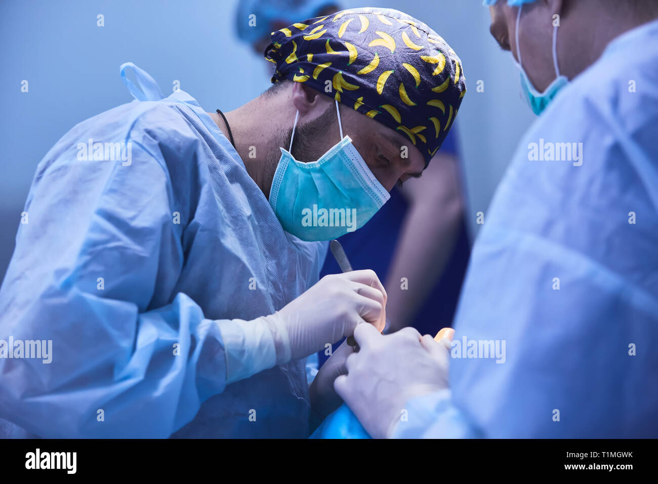 Serious surgeons during a surgery in the hospital. Cross Process Stock ...