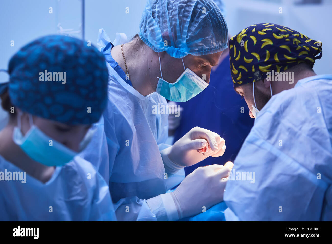 Serious surgeons during a surgery in the hospital. Cross Process Stock ...