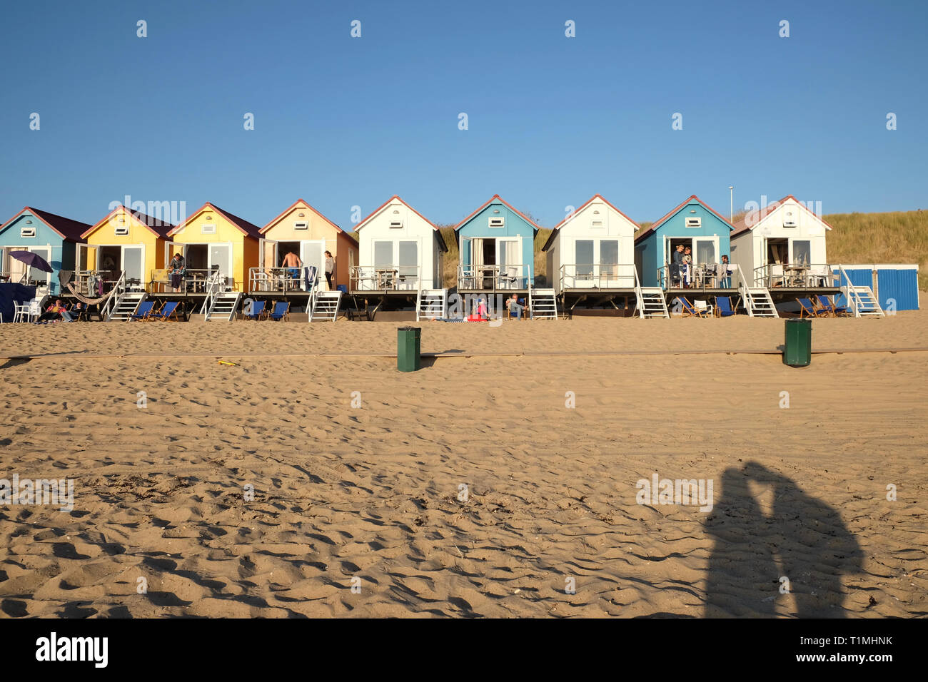 Shadows of two people at the beach in front of beach houses Stock Photo ...