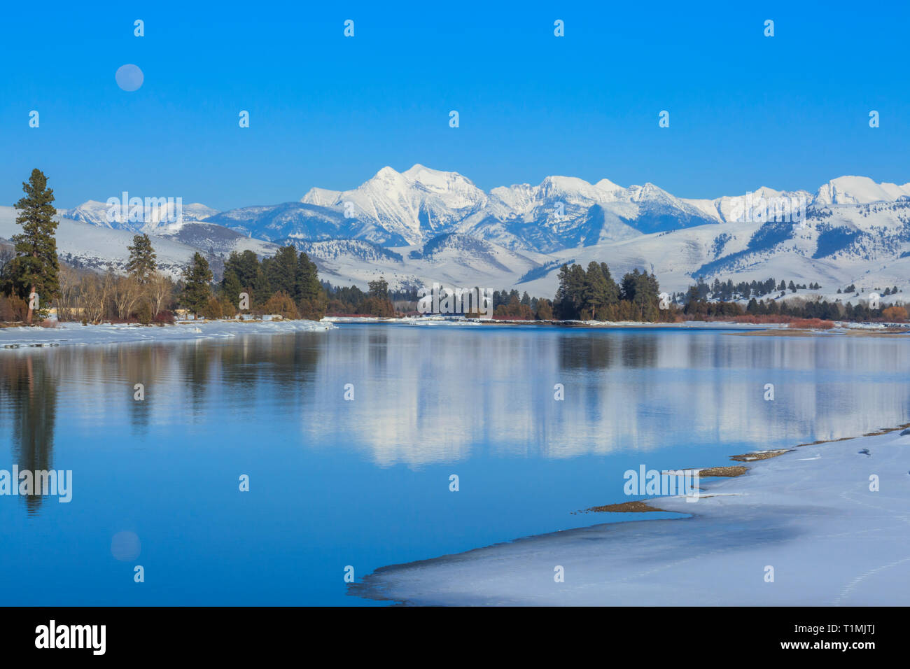 moon rising over the flathead river and mission mountains in winter ...