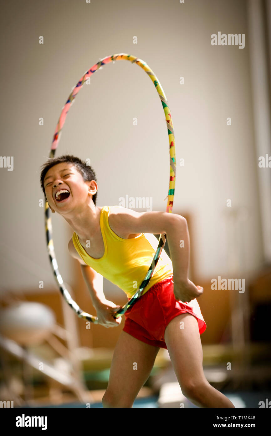Boy playing with a hula hoop in a gym Stock Photo - Alamy