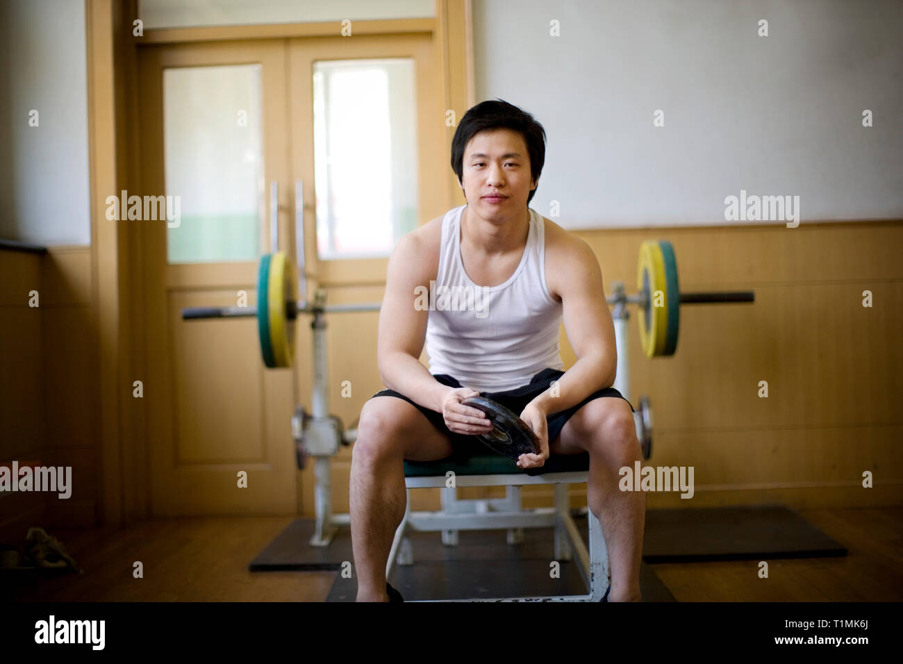 Portrait of a teenage boy sitting at the end of a bench press Stock ...