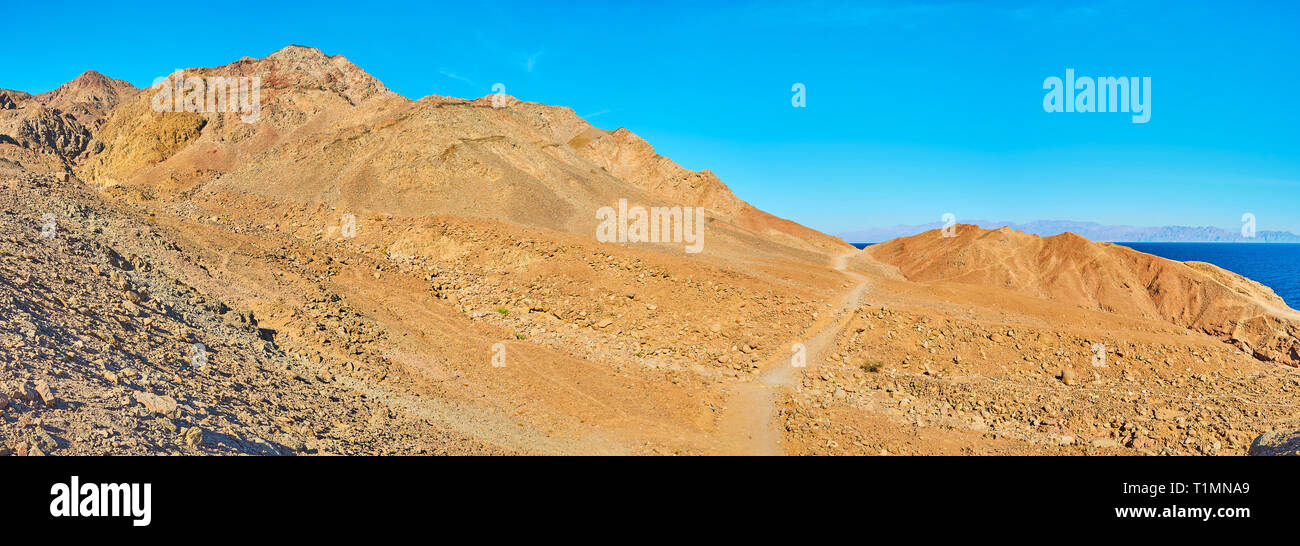 Walk along the narrow dusty footpath, stretching along the gentle rocky ...