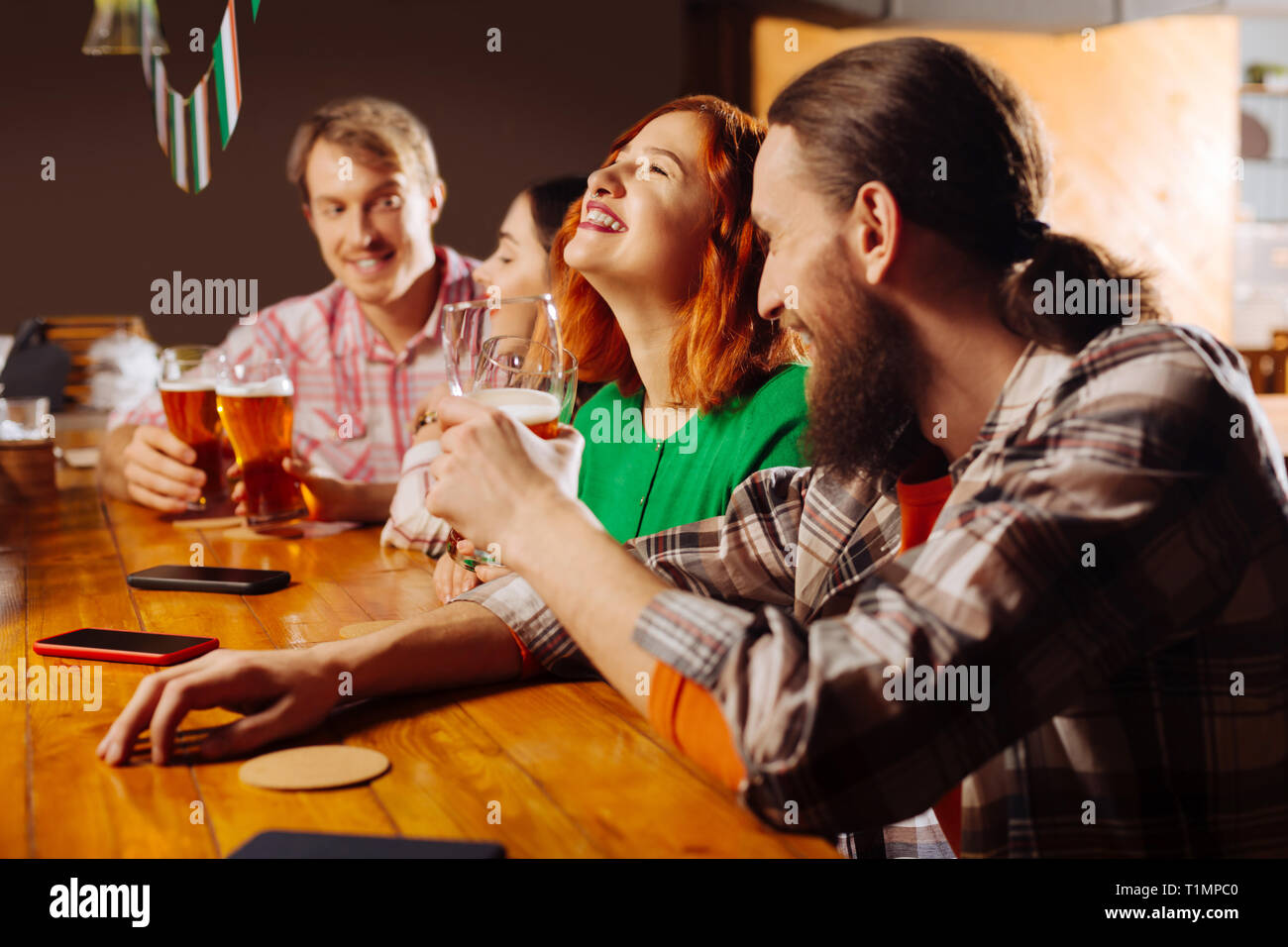 Four colleagues spending Friday night in the pub drinking beer Stock ...