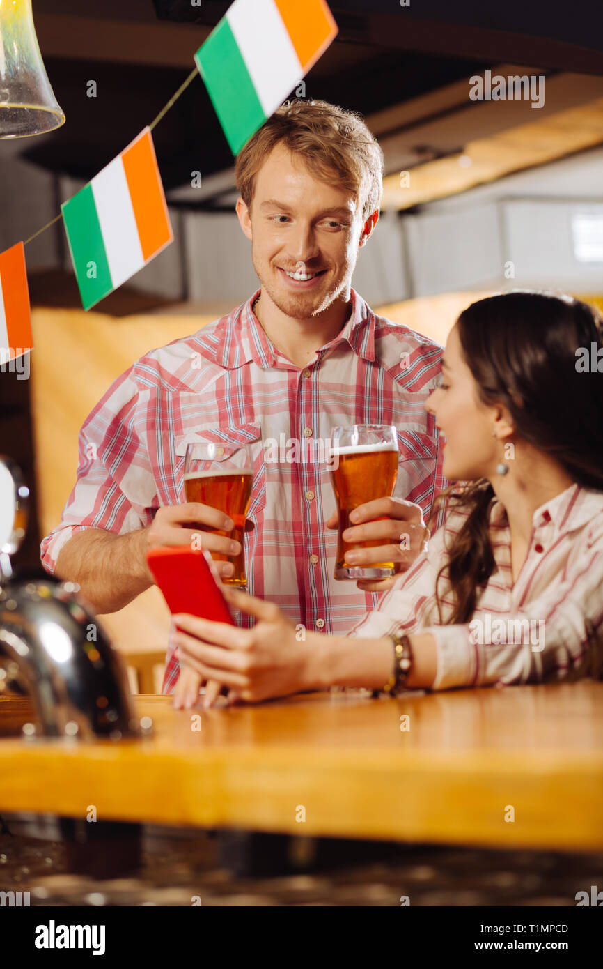 Man bringing beer while coming to woman in the bar Stock Photo - Alamy