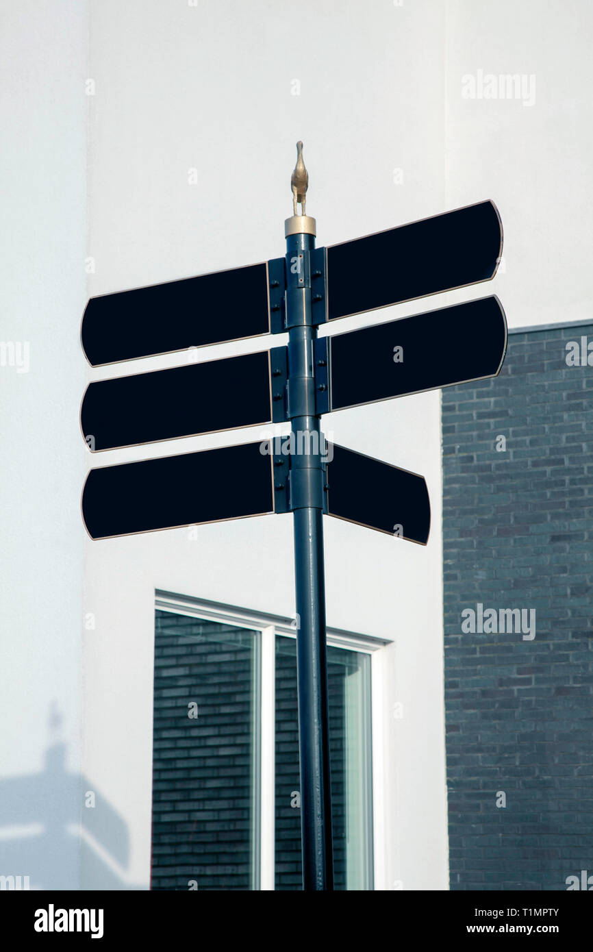 Empty dark metal pointers on the background of white house with windows ...