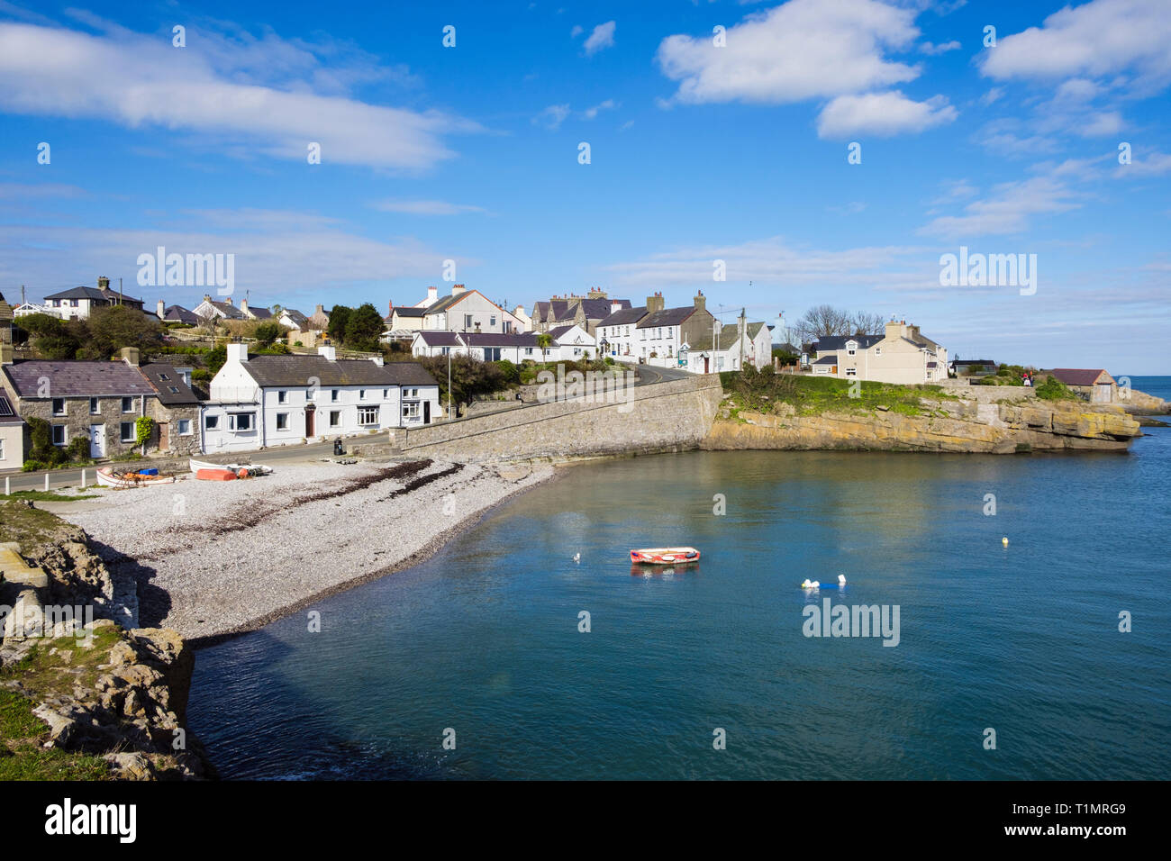View across the beach to cottages on waterfront in village of Moelfre ...