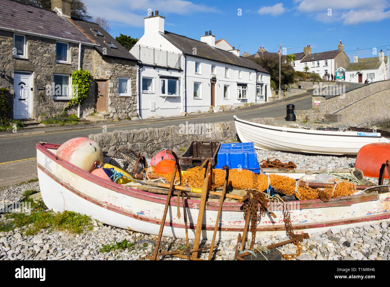 Beached fishing boats and paraphernalia on beach in village of Moelfre ...