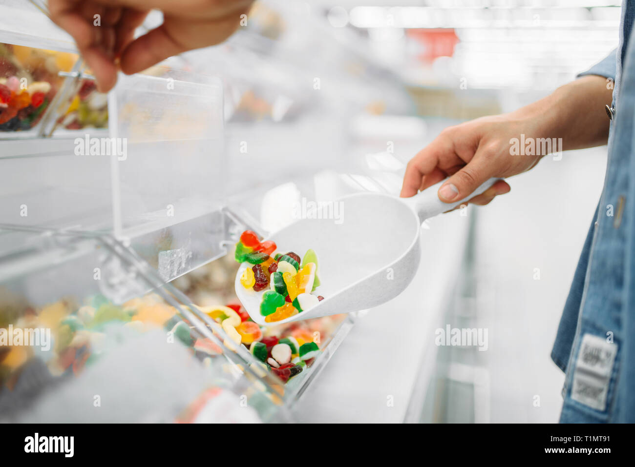 Male person picks up package of sweet chewy candy Stock Photo - Alamy