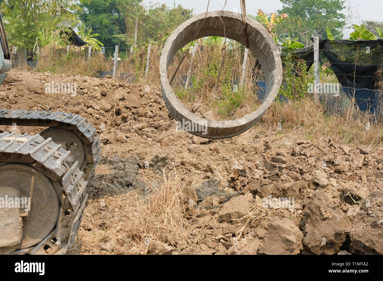 excavator backhoe tractor raising pipe at construction site Stock Photo ...