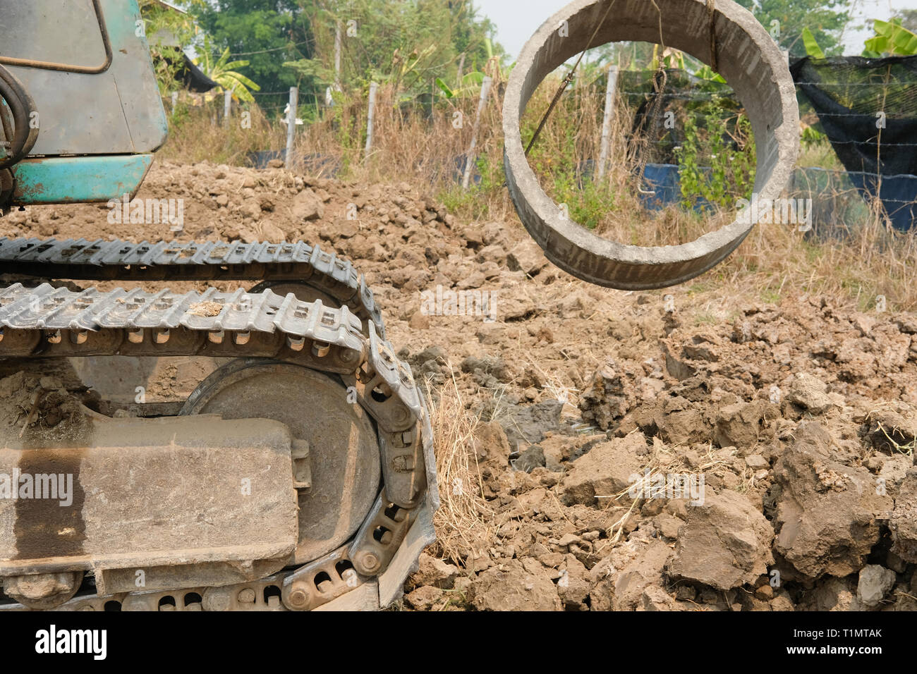 excavator backhoe tractor raising pipe at construction site Stock Photo ...