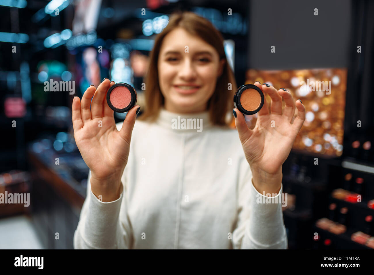 Female customer shows cosmetics in the makeup shop Stock Photo - Alamy