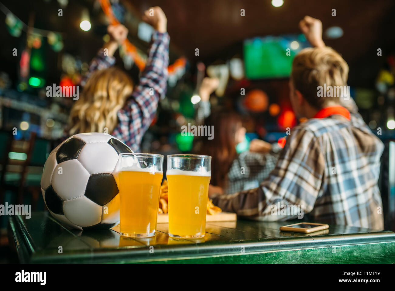 Ball and beer in sports bar, game watching concept Stock Photo - Alamy