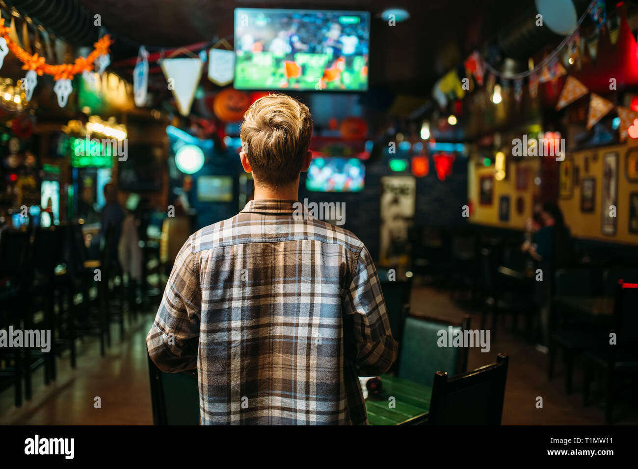 Football fan watching the match in sports bar Stock Photo - Alamy