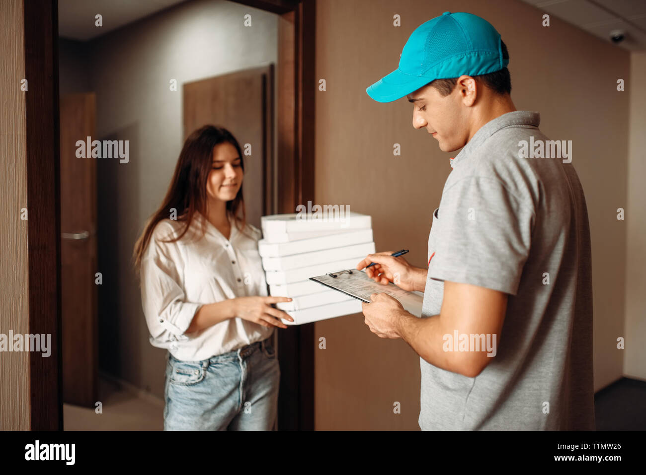 Female customer signs order, pizza delivery Stock Photo - Alamy