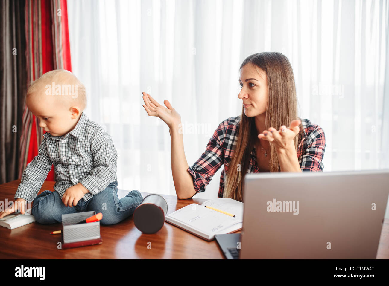 Mother works, kid helps her, motherhood problems Stock Photo - Alamy