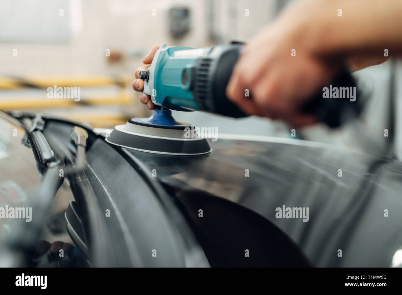 Male person with polishing machine cleans car Stock Photo - Alamy