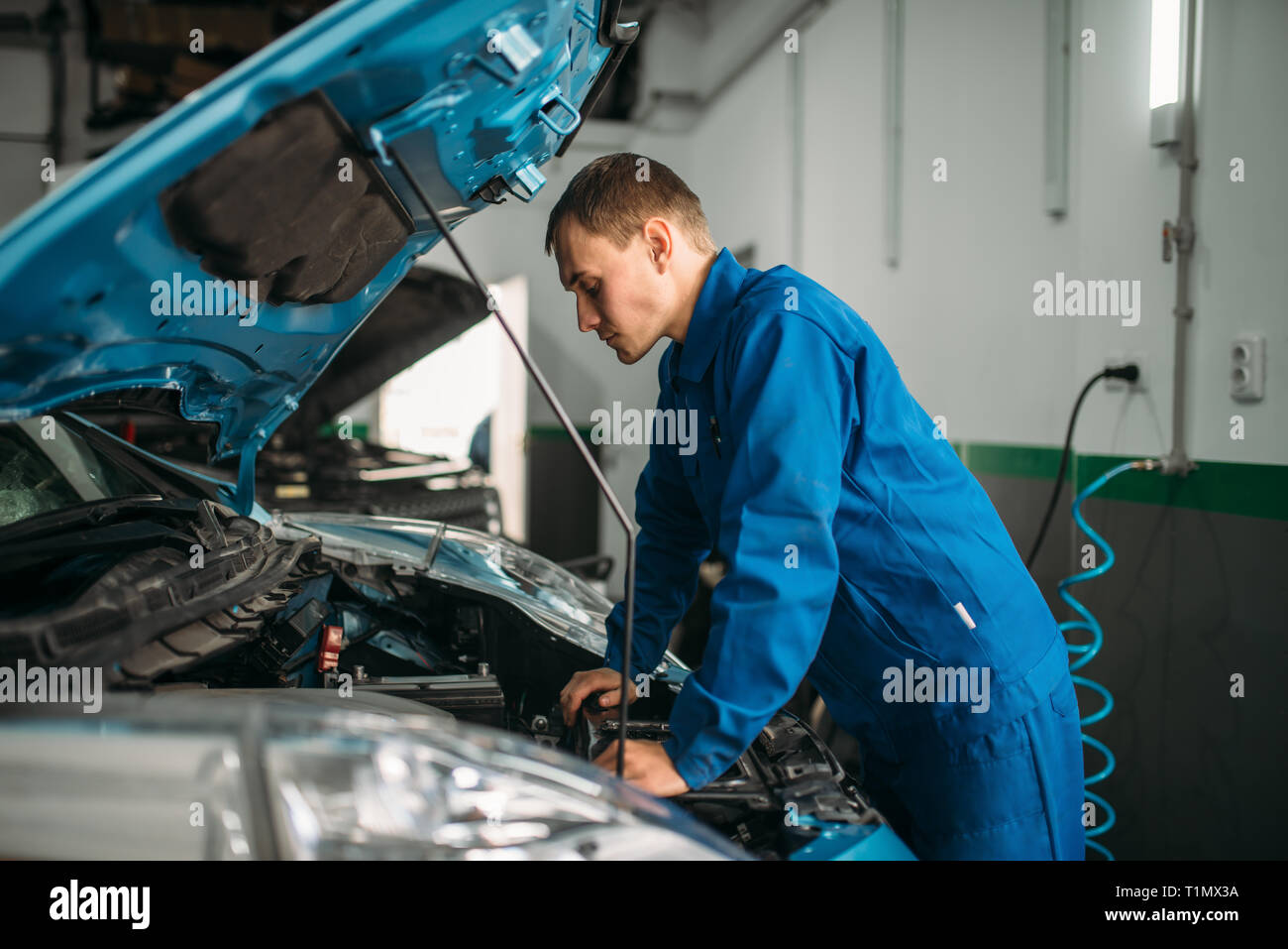 Mechanic makes visual inspection of the car engine Stock Photo - Alamy