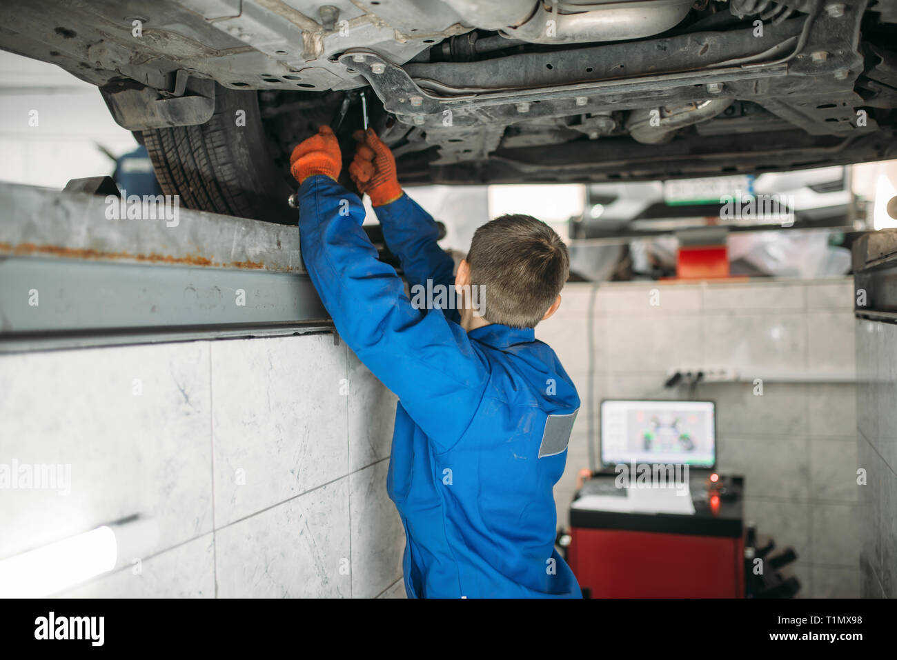 Mechanic adjusts the wheel angles on stand Stock Photo - Alamy