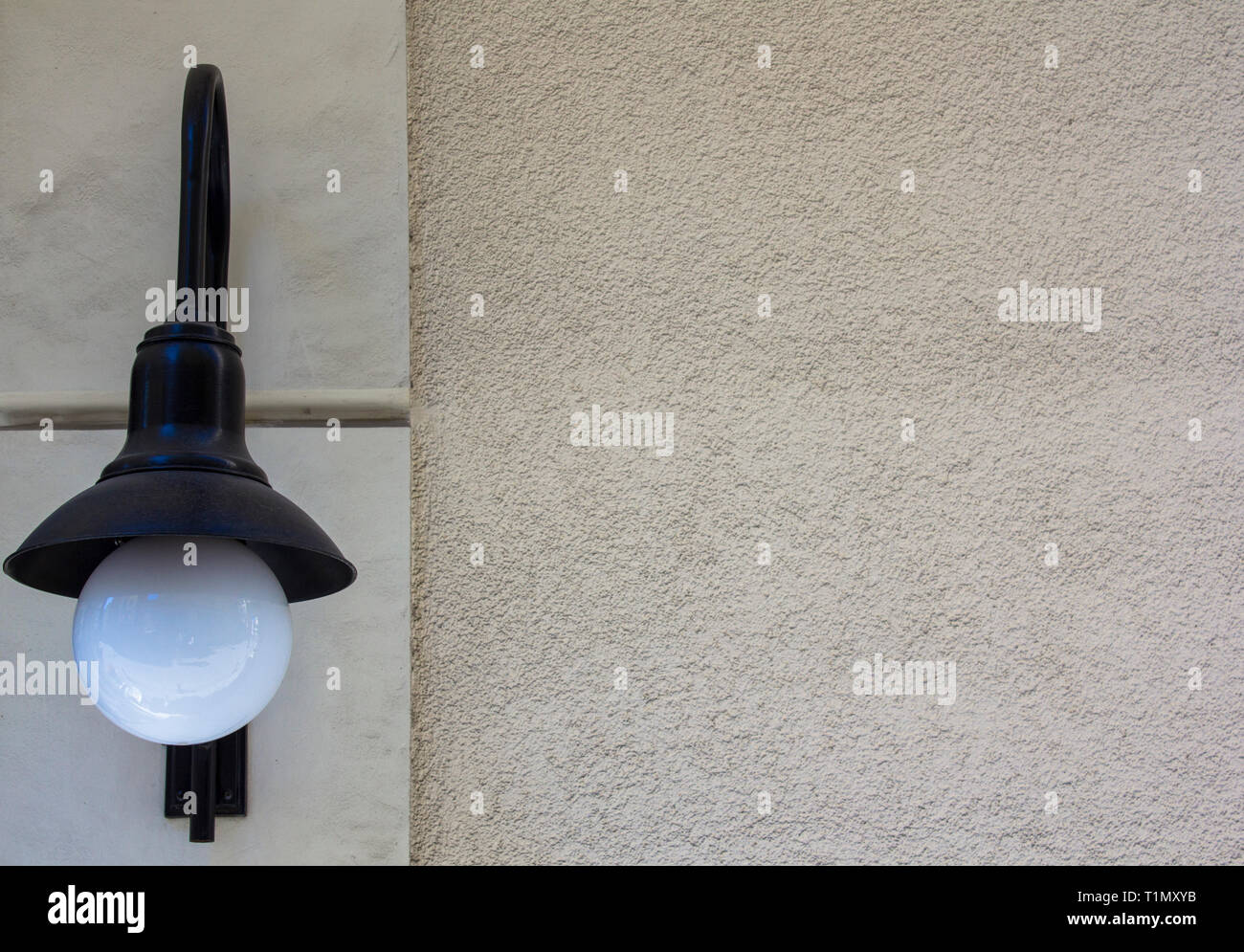 Black wall lantern with a round white lamp. Lantern beside and empty ...