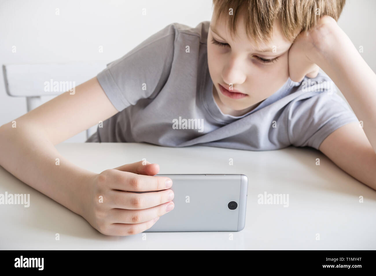 Teen boy watching video in smartphone. Selective focus on smartphone ...