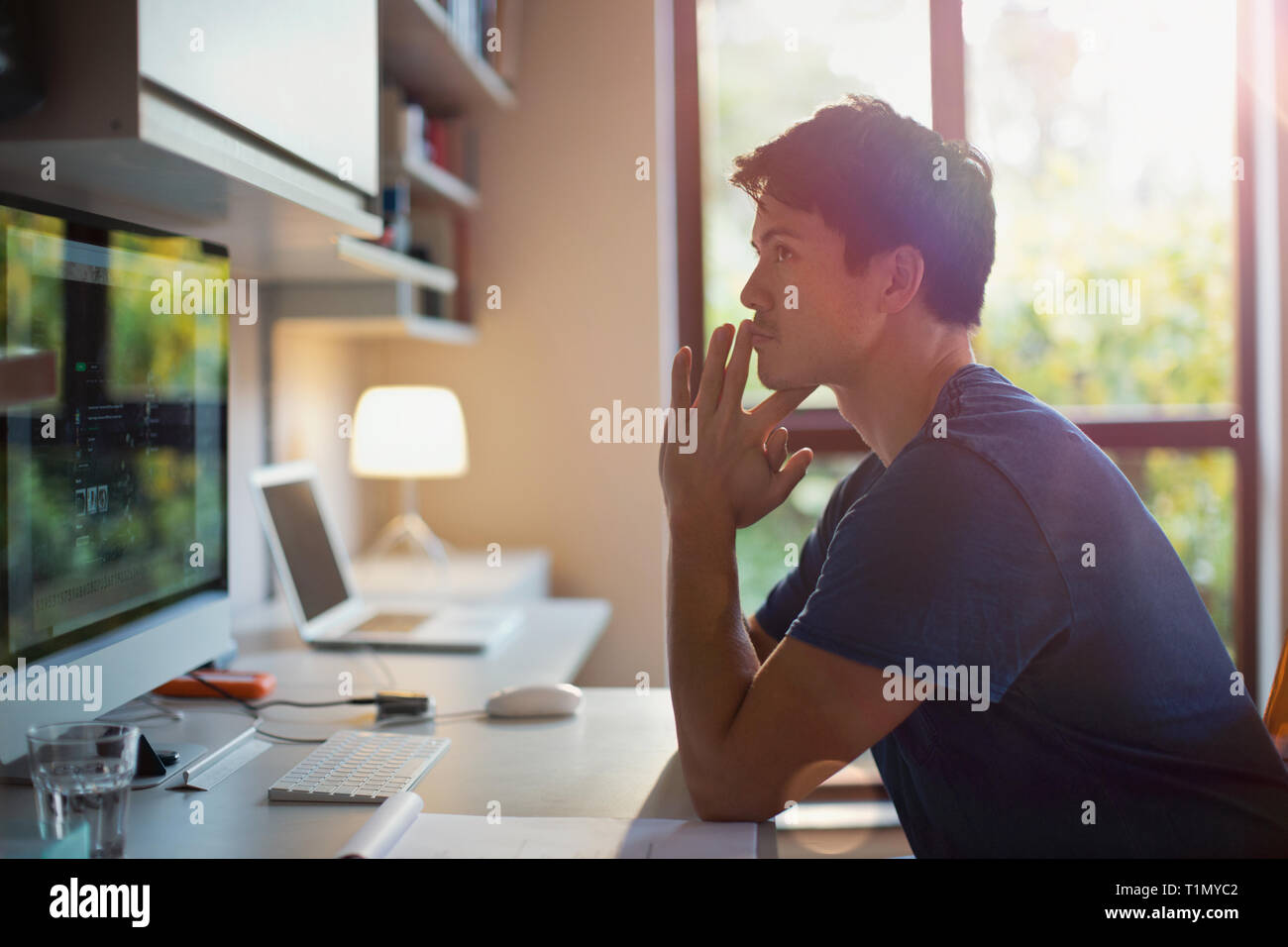 Thoughtful man working at computer in home office Stock Photo - Alamy