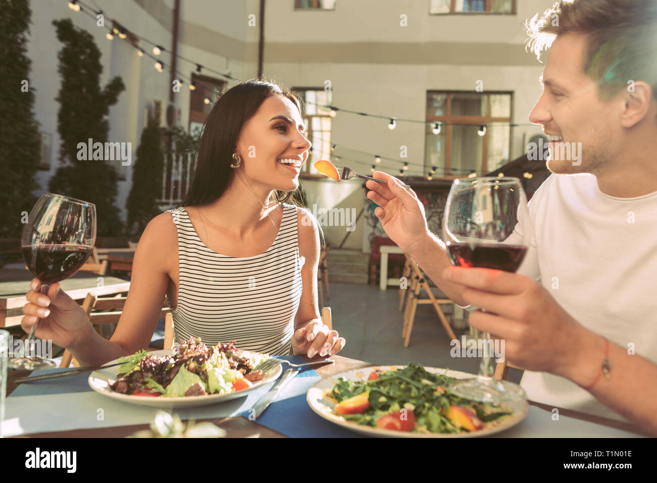 Smiling short-haired man with glass of red wine in one hand Stock Photo ...