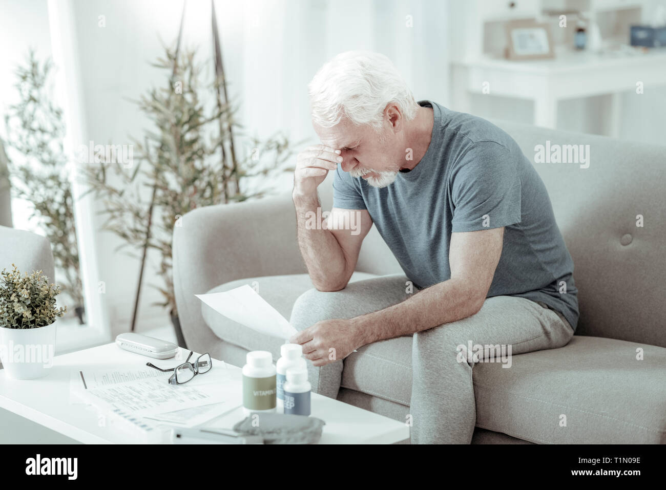 Sorrowful grey-haired patient feeling blue after considering assessment ...