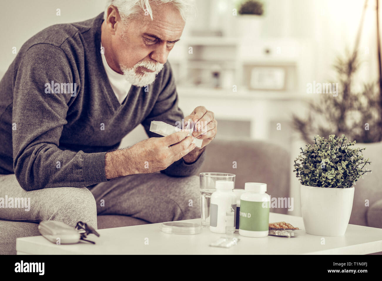 Portrait of elderly ill man holding pills box in hands Stock Photo - Alamy