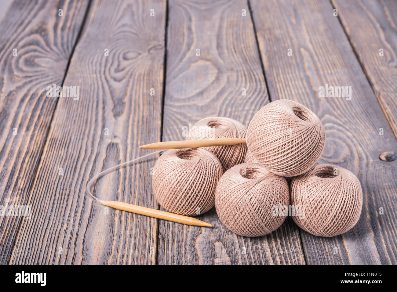 Balls of yarn and knitting needles for knitting on a wooden background ...
