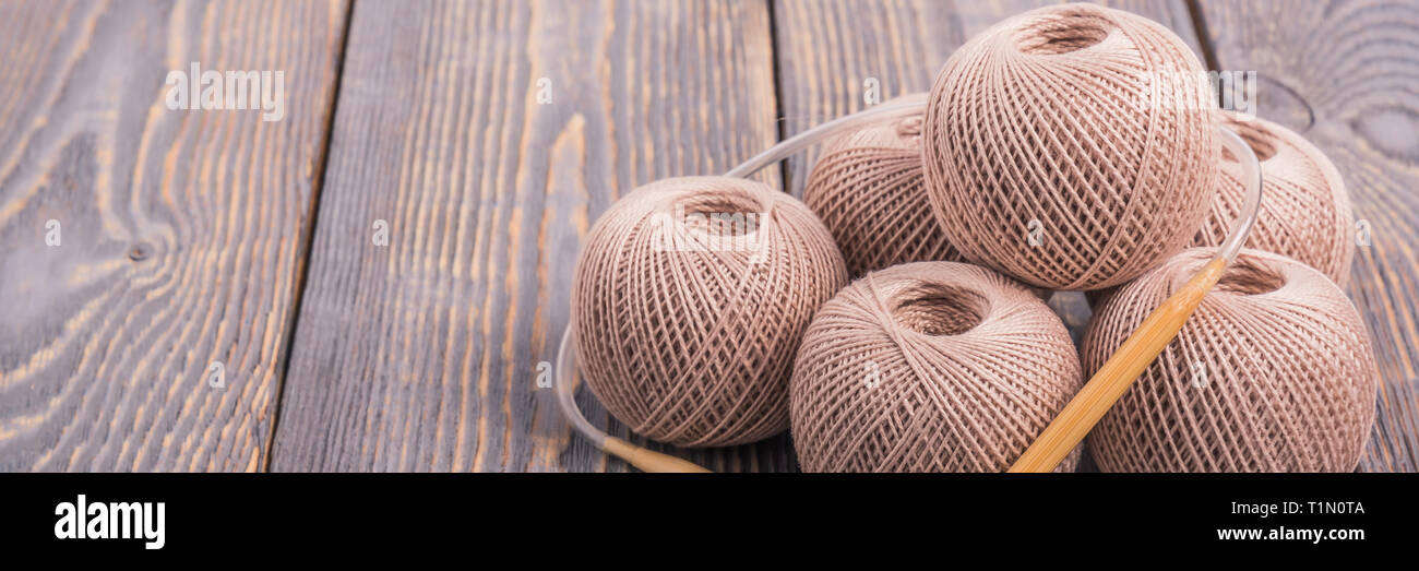 Balls of yarn and knitting needles for knitting on a wooden background ...