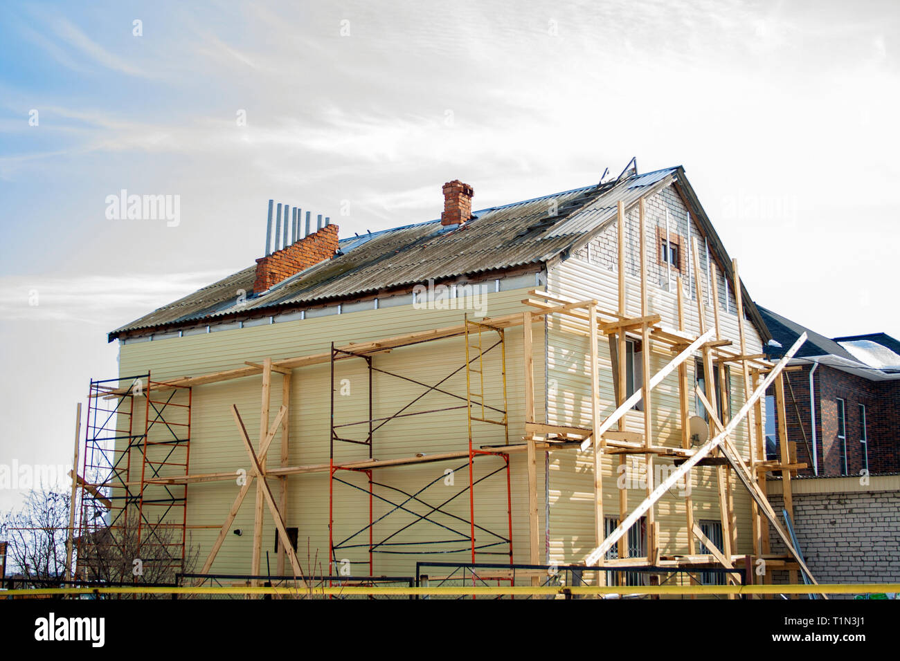 House and scaffolding construction at sunny day. Process of building ...