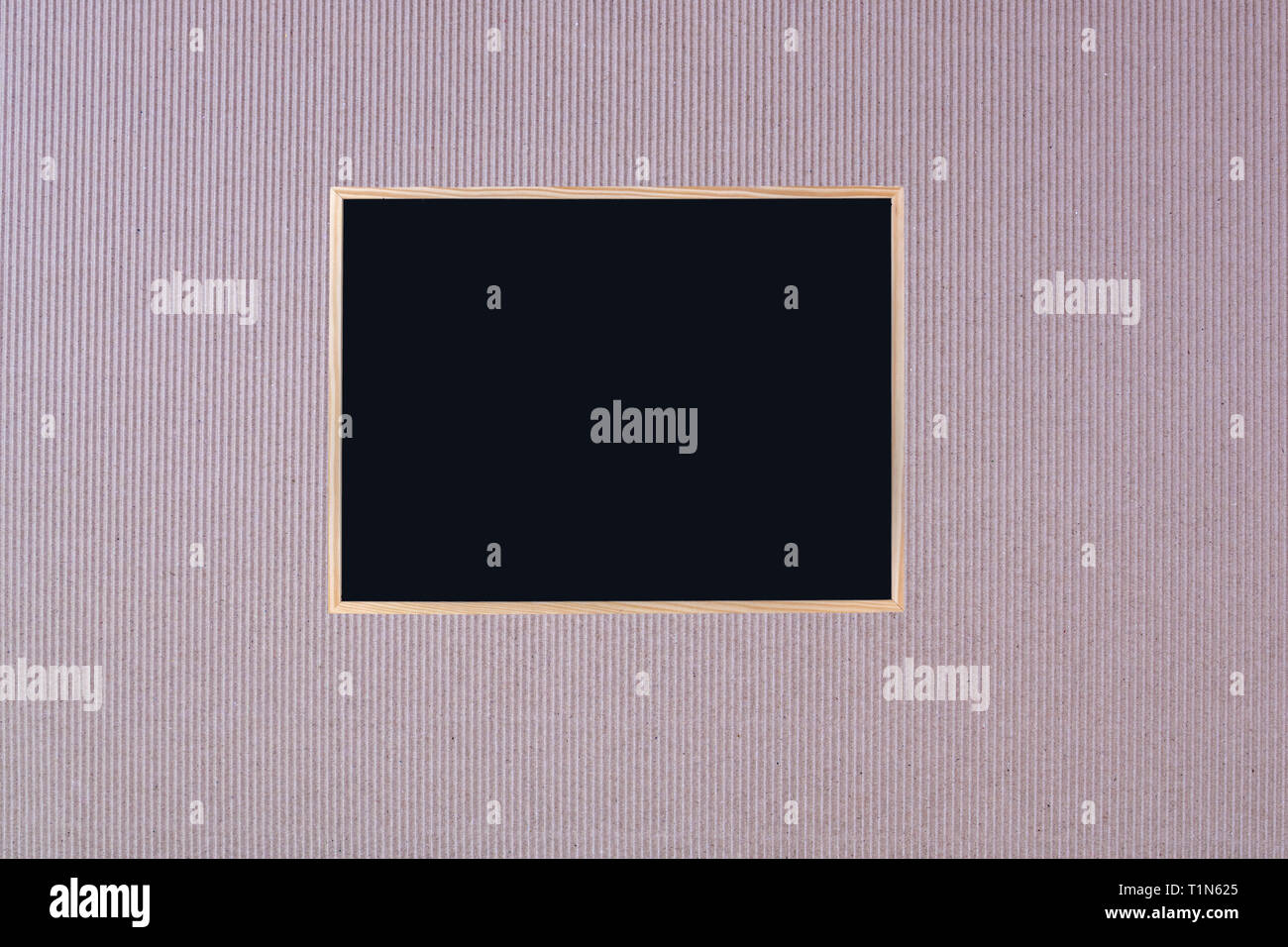 Front view of a blank blackboard over a cardboard background surface ...